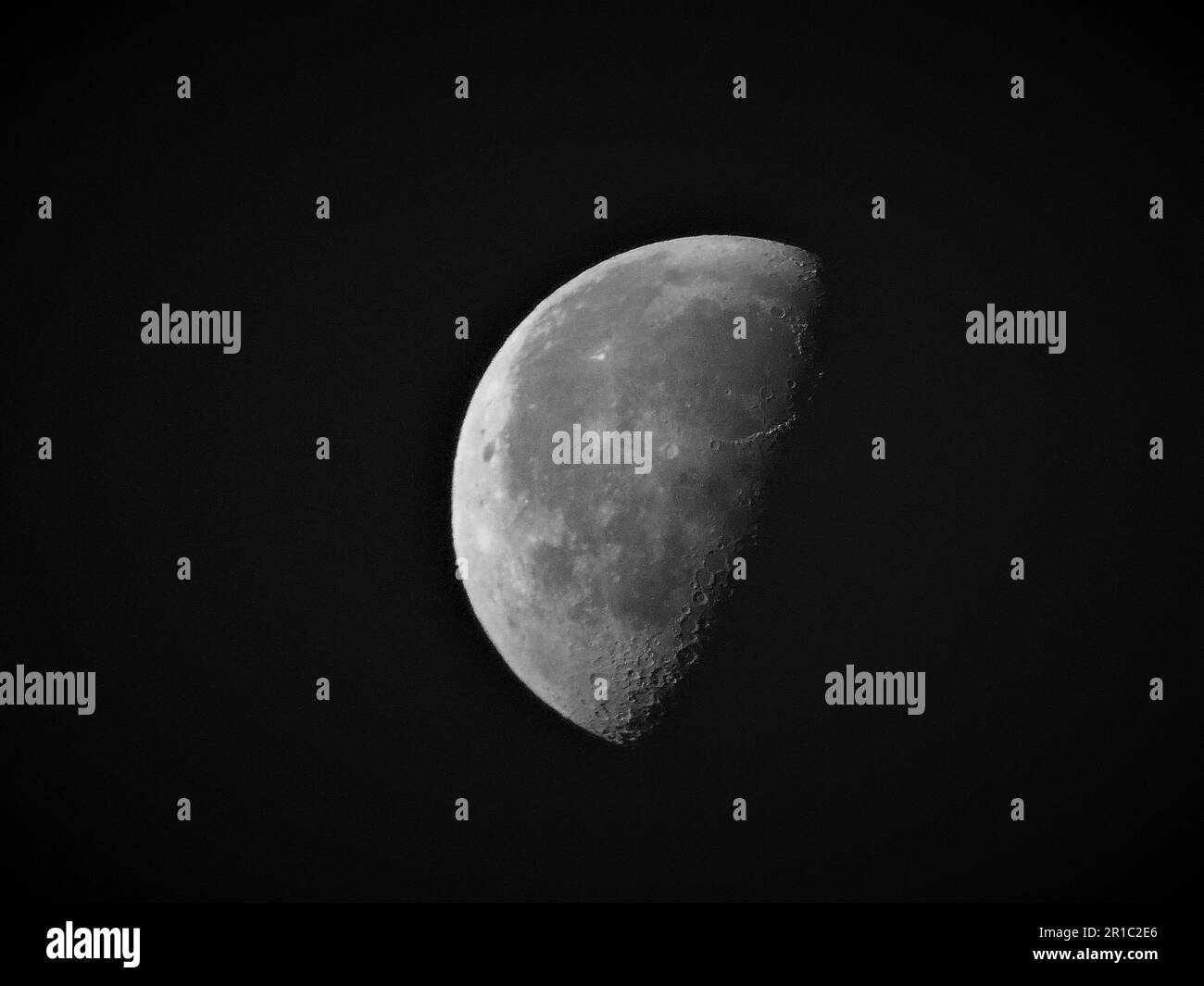 A full moon in a night sky, set against a crisp black and white filter ...