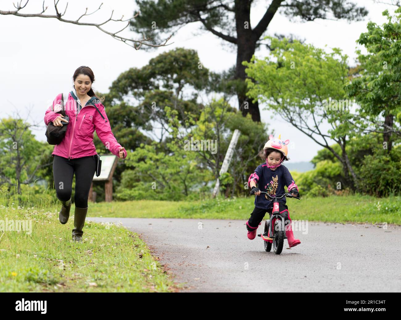 Learning to ride a balance bike Stock Photo - Alamy