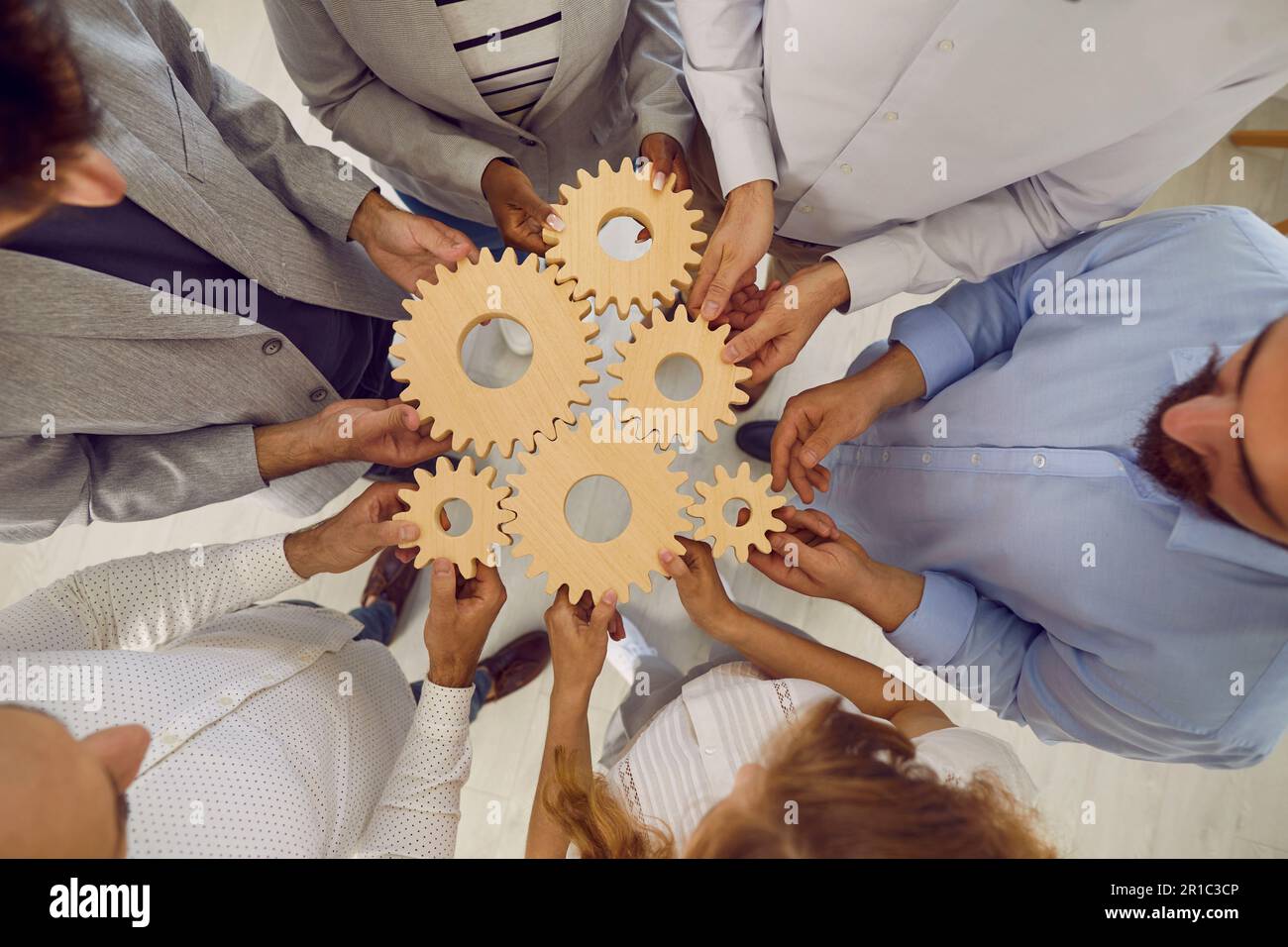 Group of creative business people joining together wooden gears at ...