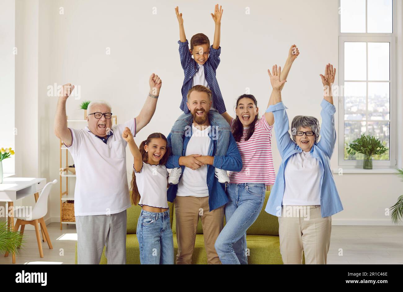 Happy big family parents, grandsparents, kids with hands rising up at ...