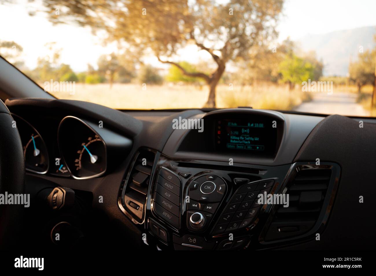 A modern car interior with its dashboard lit up, featuring a steering ...