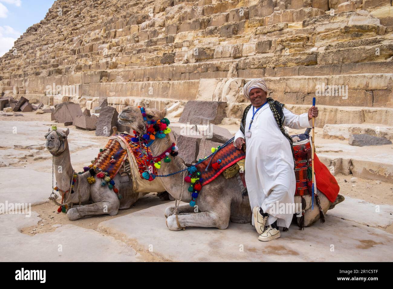Man posing next to his camels at the Giza pyramids in Cairo, Egypt ...
