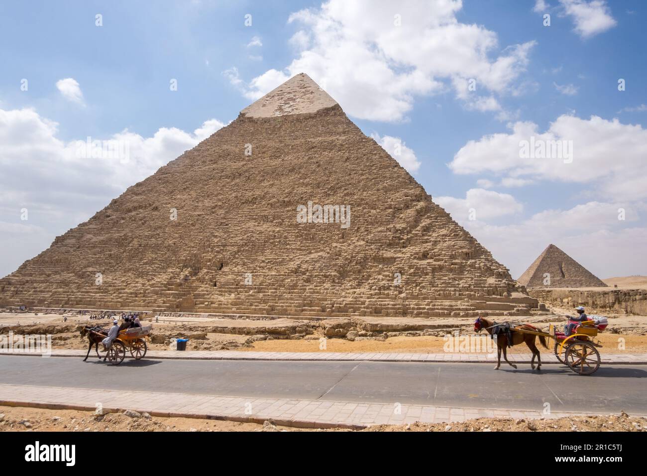 Horse-drawn carriages driving next to Khafre's pyramid in Cairo, Egypt ...