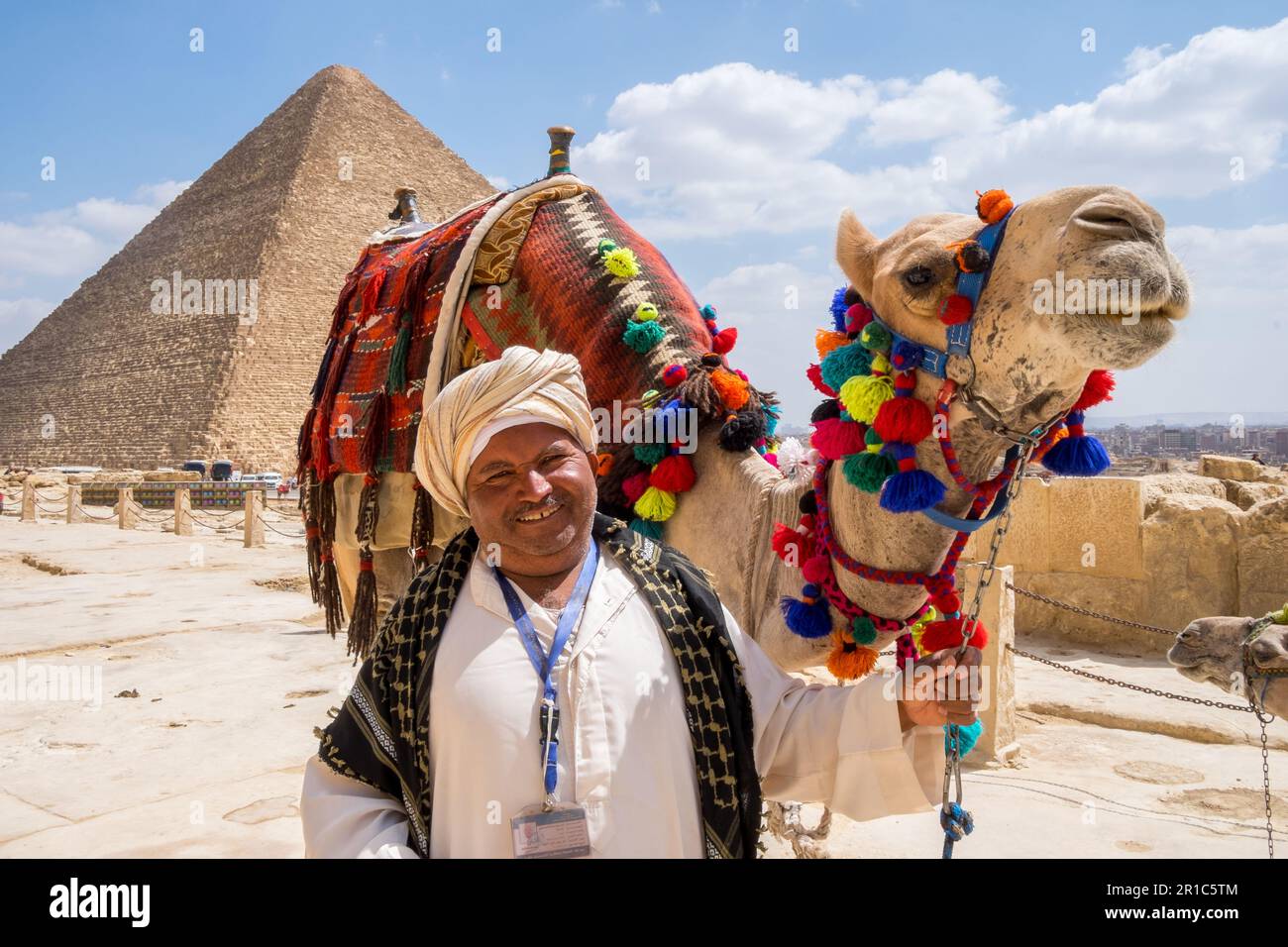 Portrait of a man next to his camel and view of the Great Pyramid of ...