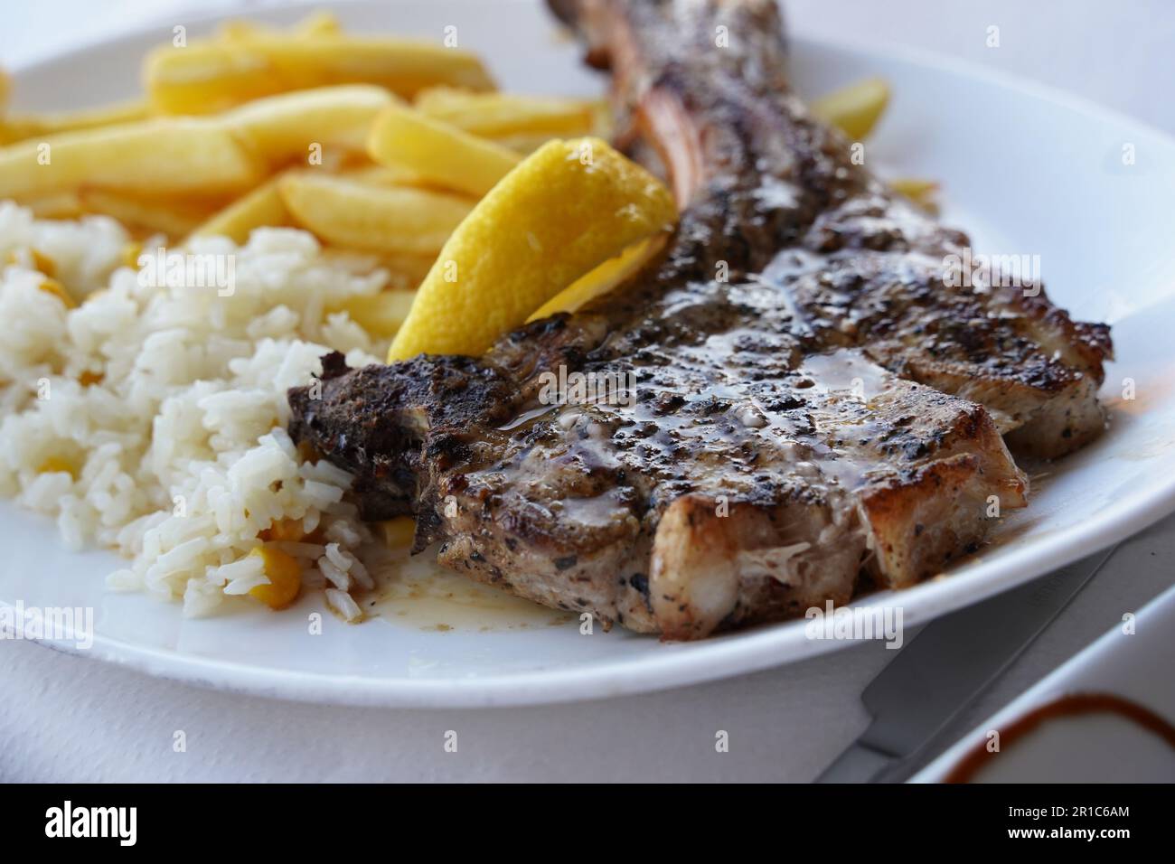 Grilled Giant Pork Chop with chips and salad Stock Photo - Alamy