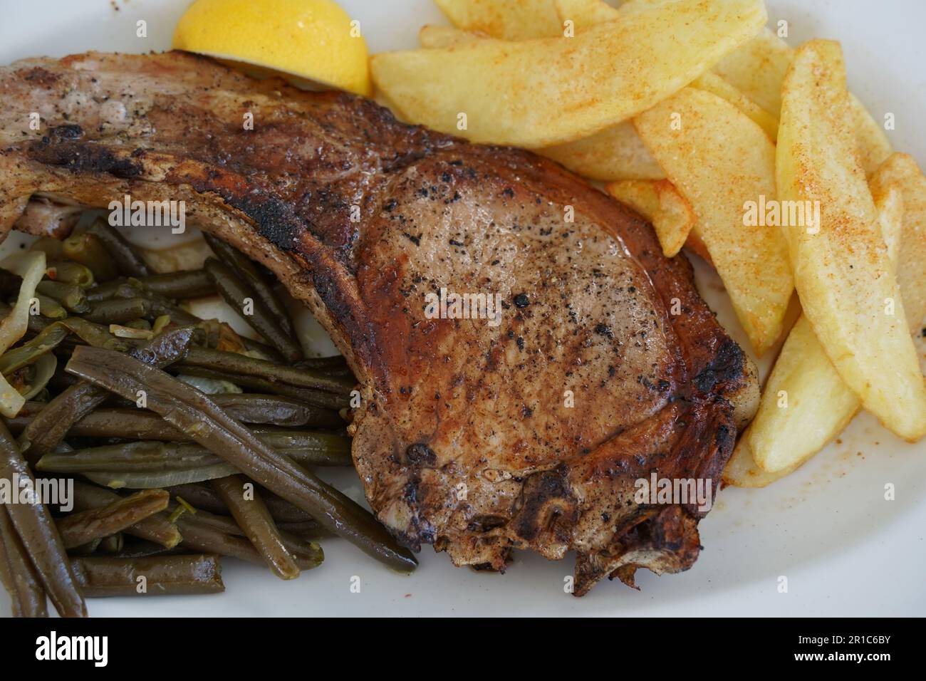 Grilled Giant Pork Chop with chips and salad Stock Photo - Alamy