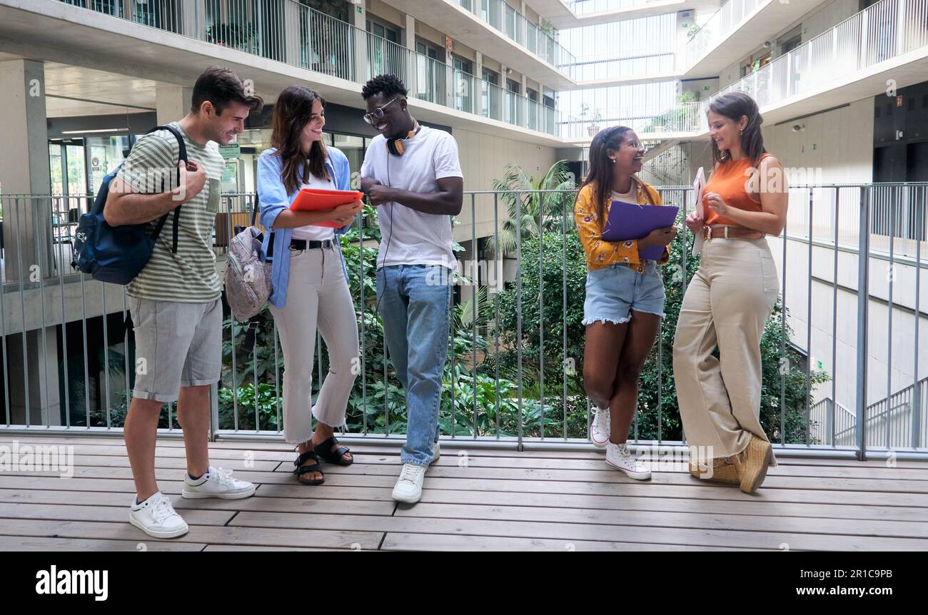 Cheerful group of young interracial students standing together at high ...