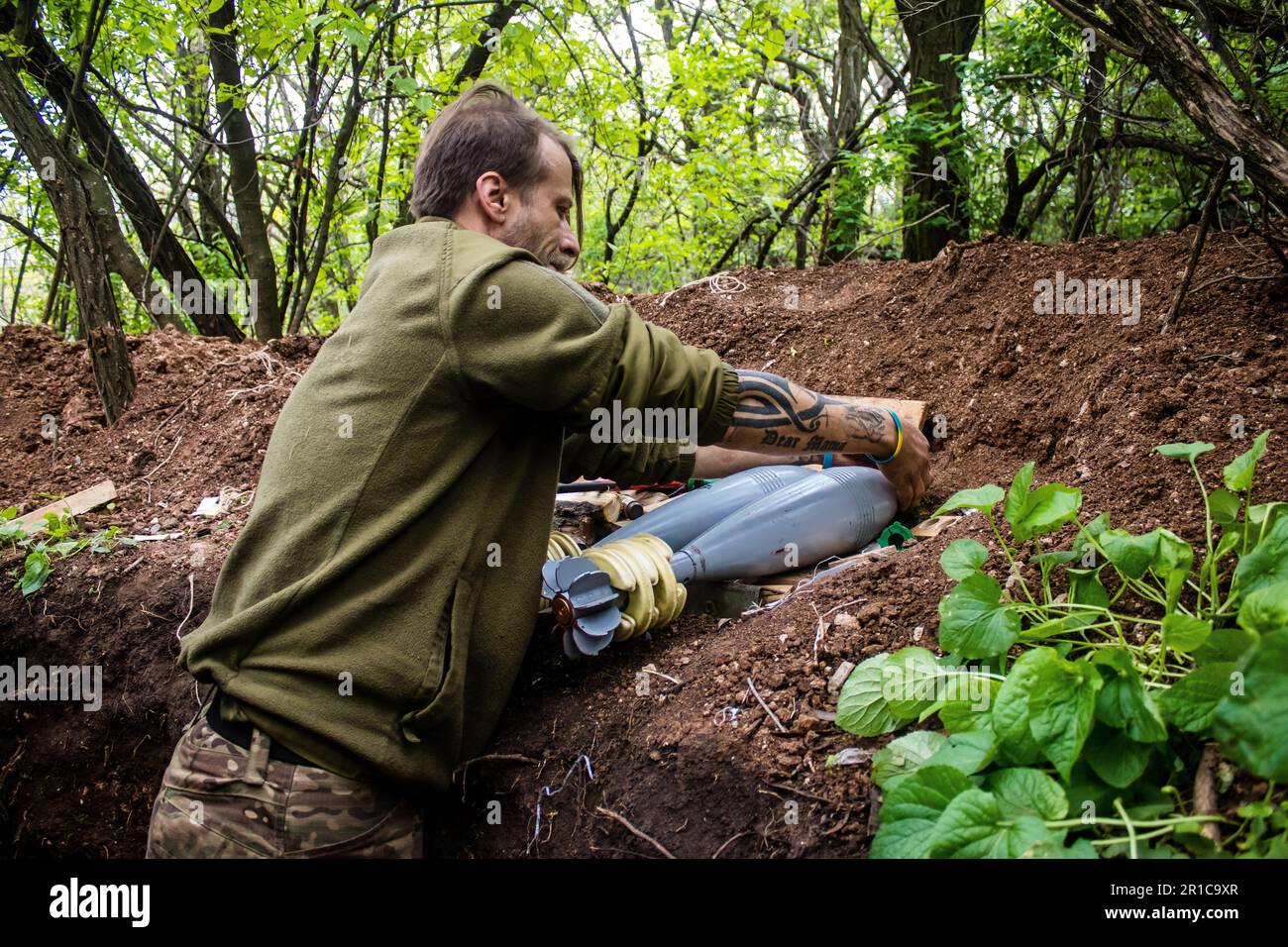 Ukrainian soldier of the 28th Artillery Battalion preparing a shell for ...