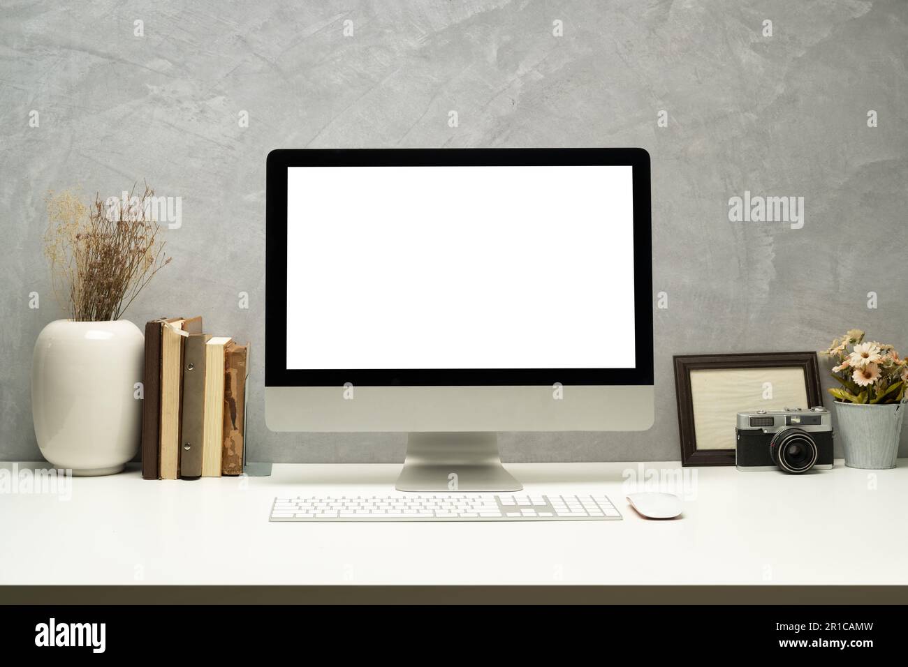 Stylish workplace with blank screen computer, picture frame and books ...