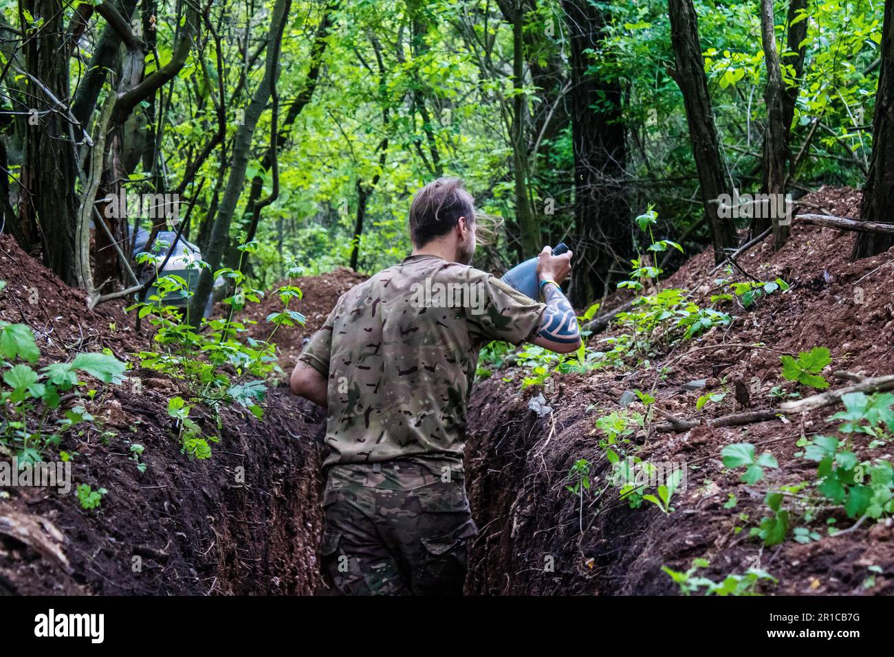 Ukrainian soldier from the 28th Artillery Battalion carrying a shell of ...
