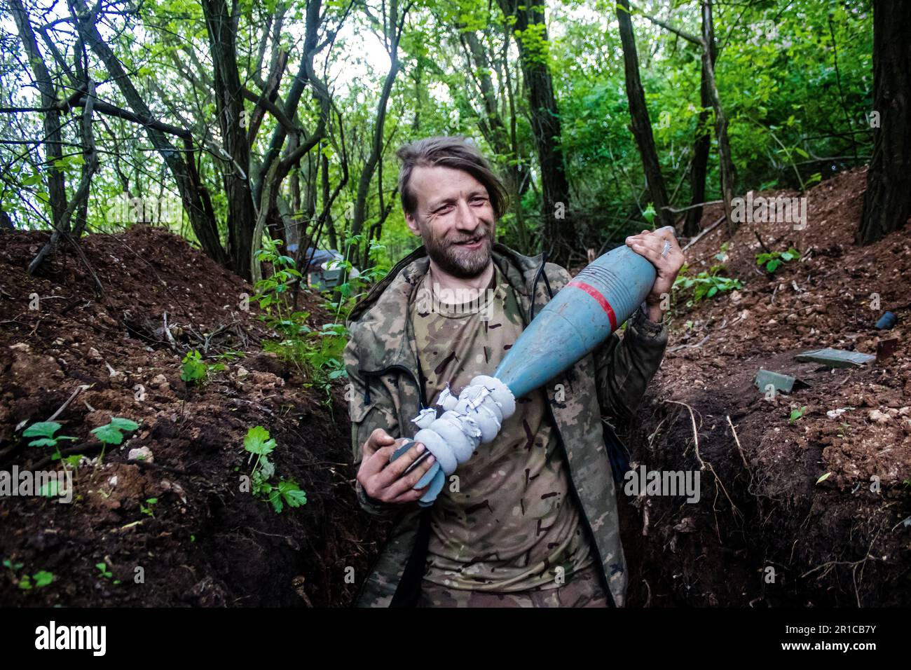 Ukrainian soldier from the 28th Artillery Battalion carrying a shell of ...