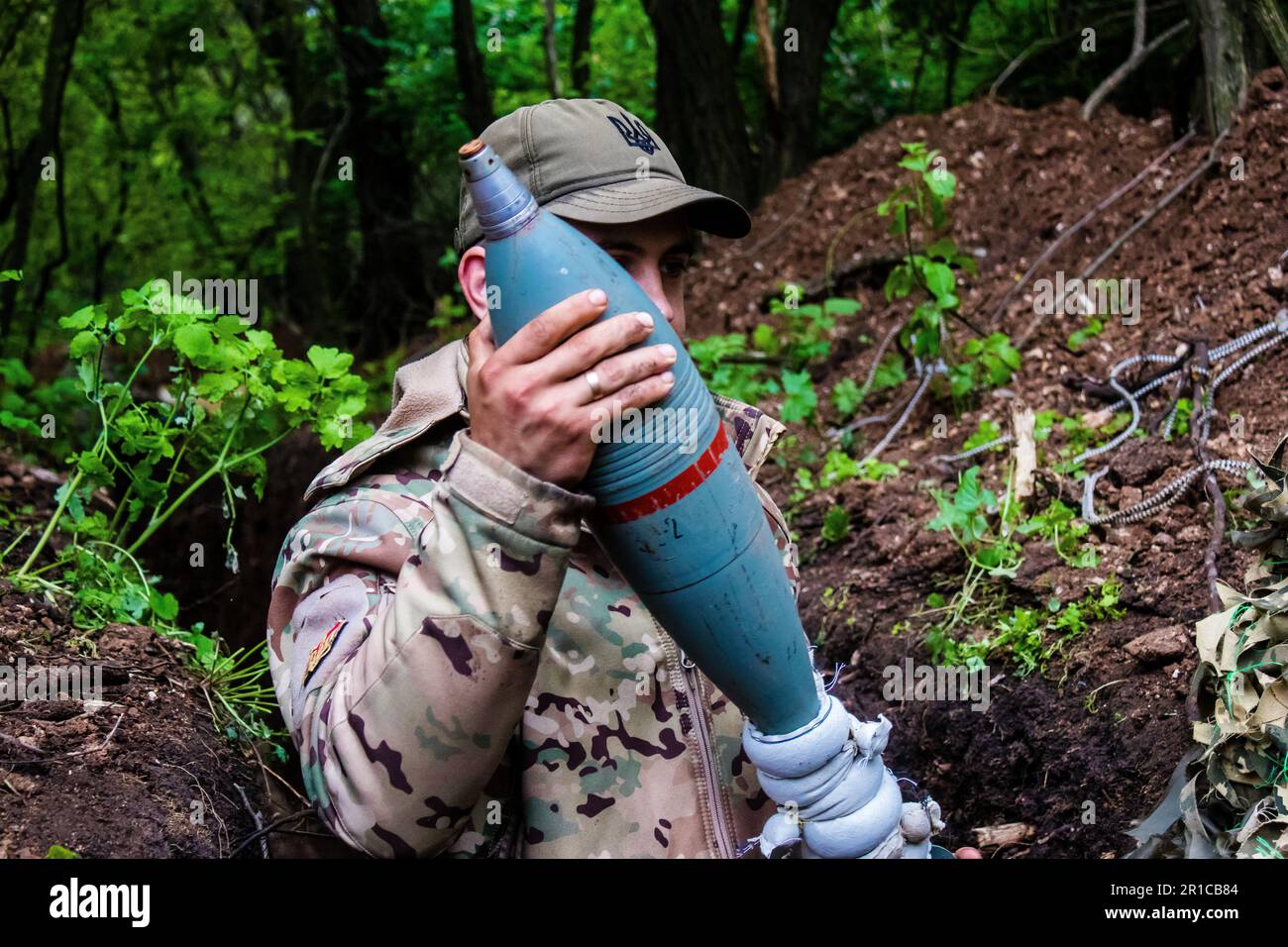 Ukrainian soldier from the 28th Artillery Battalion carrying a shell of ...