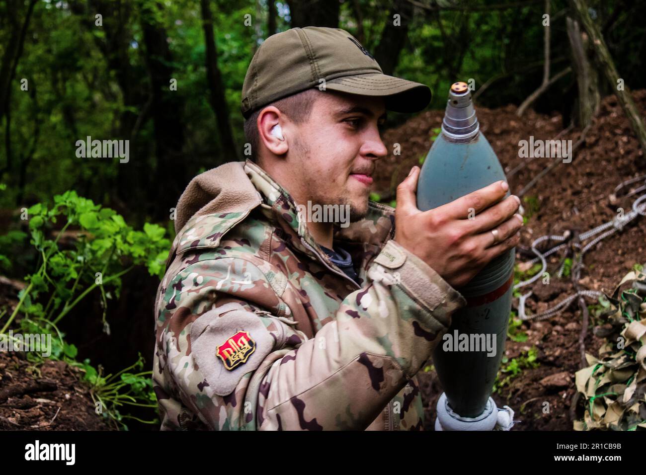 Ukrainian soldier from the 28th Artillery Battalion carrying a shell of ...