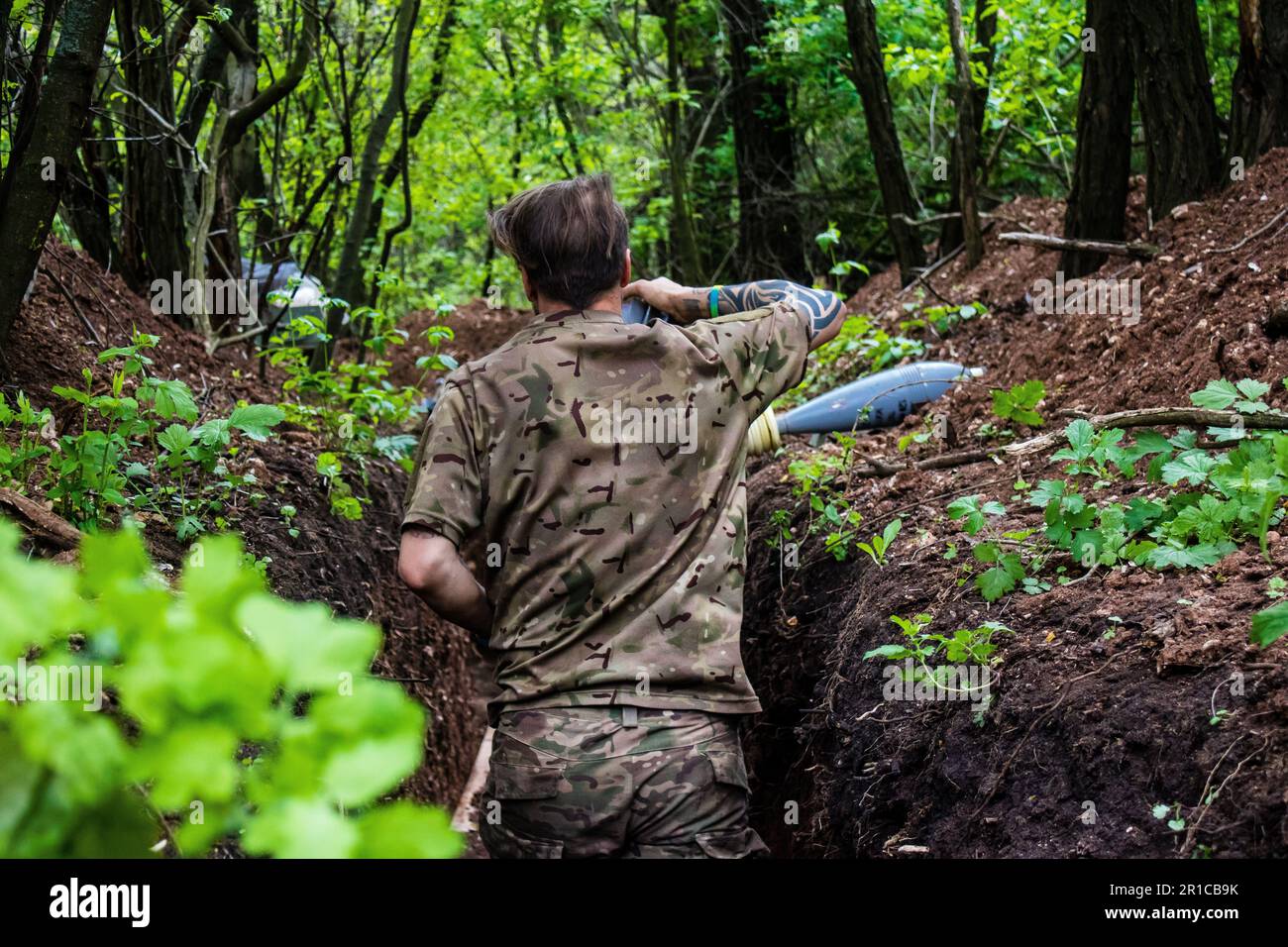 Ukrainian soldier from the 28th Artillery Battalion carrying a shell of ...
