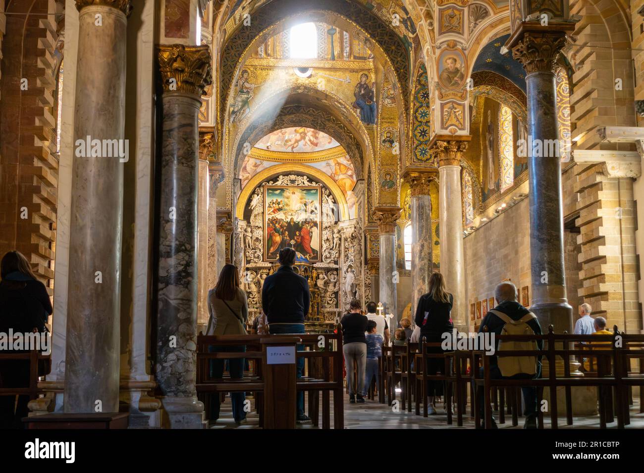People attend mass in church a sunshine ray enters through a window ...