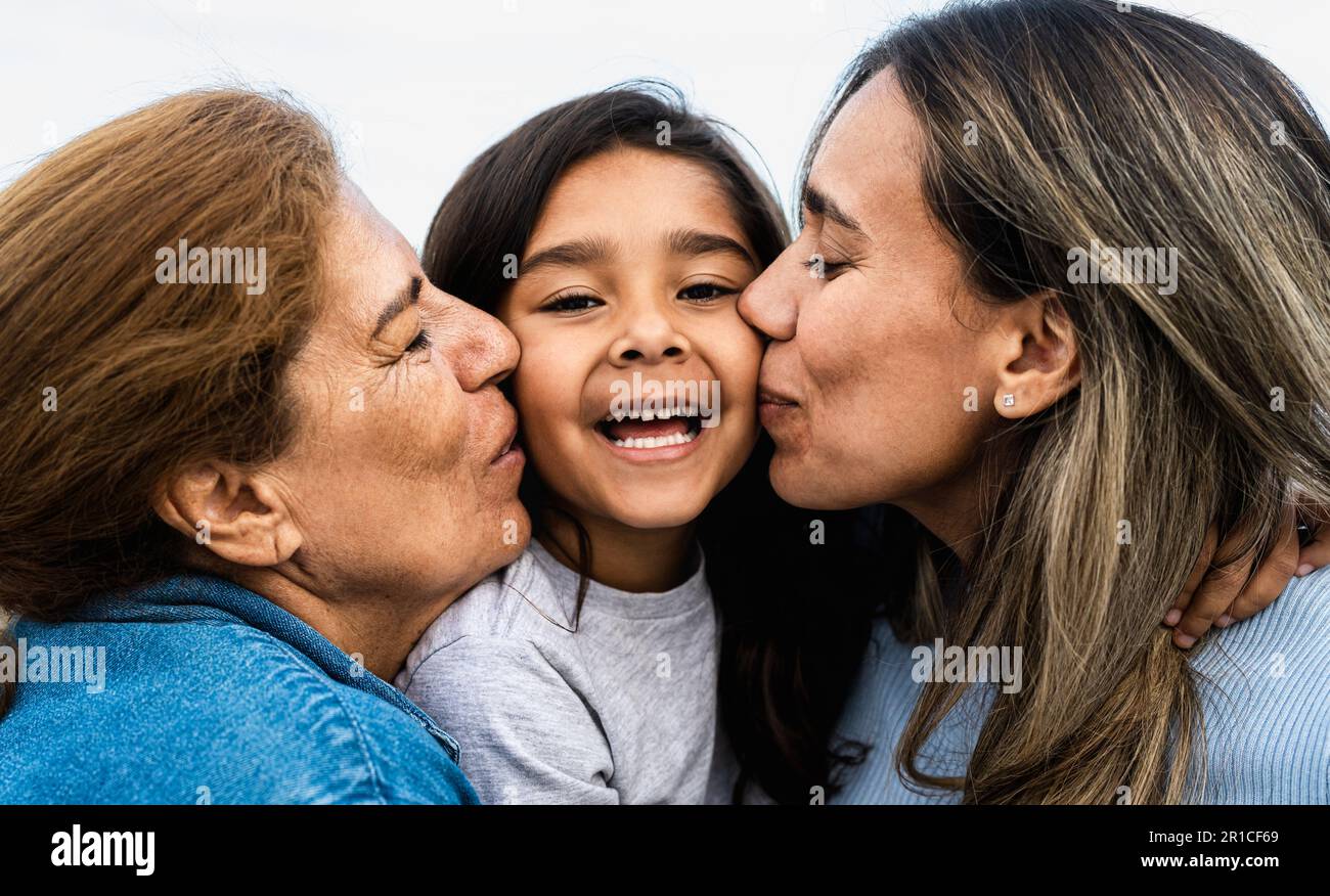 Happy Hispanic family enjoying time together - Child having fun with her mother and grandmother ...
