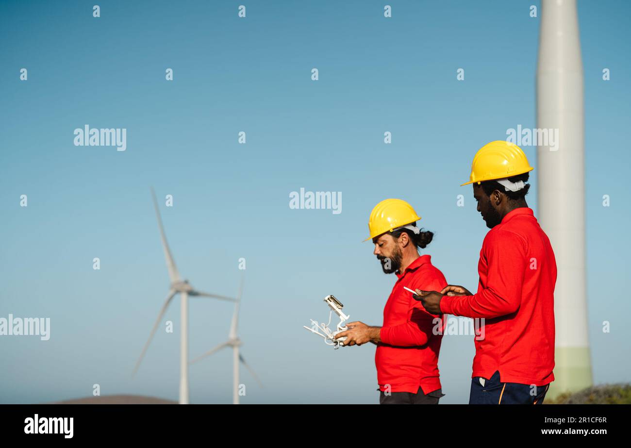 Drone engineers working on wind turbine farm - Alternative energy and ...