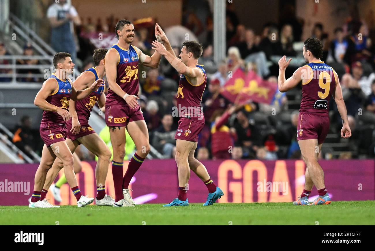 Joe Daniher (centre) of the Lions celebrates kicking a goal with team ...
