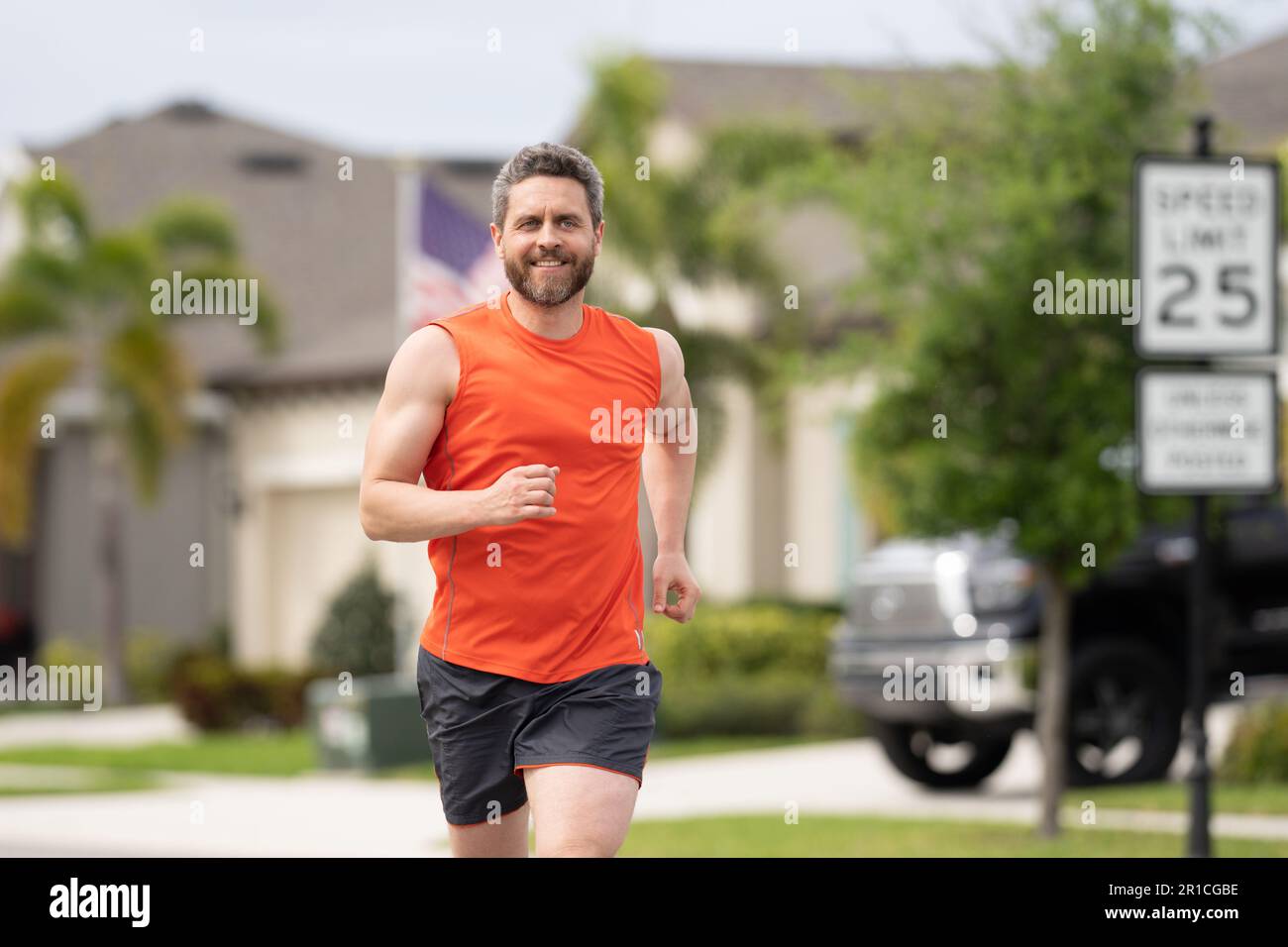 Handsome middle aged man running across american neighborhood. Athletic ...