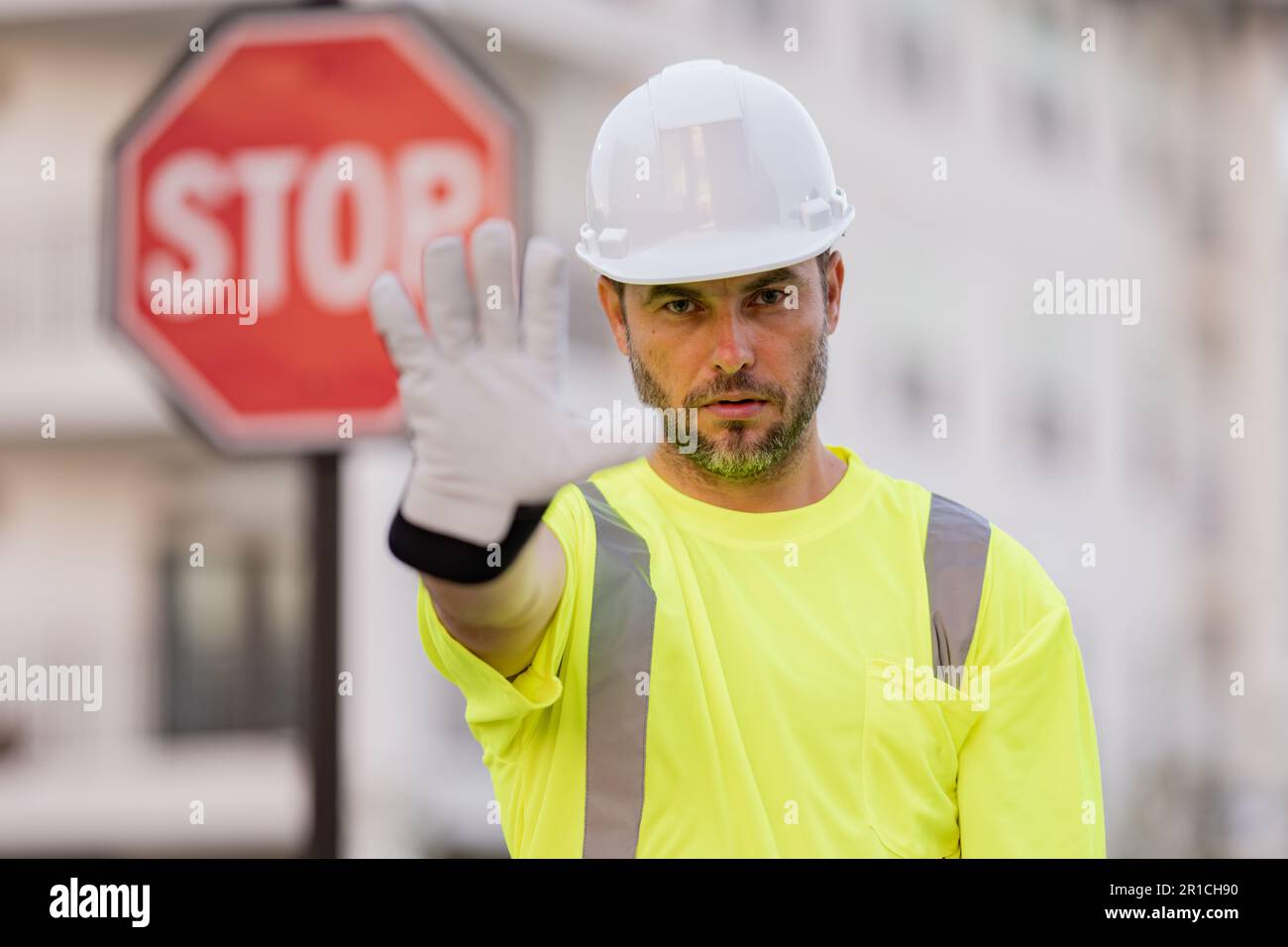 Serious engineer with stop road sign. Builder with stop gesture, no ...