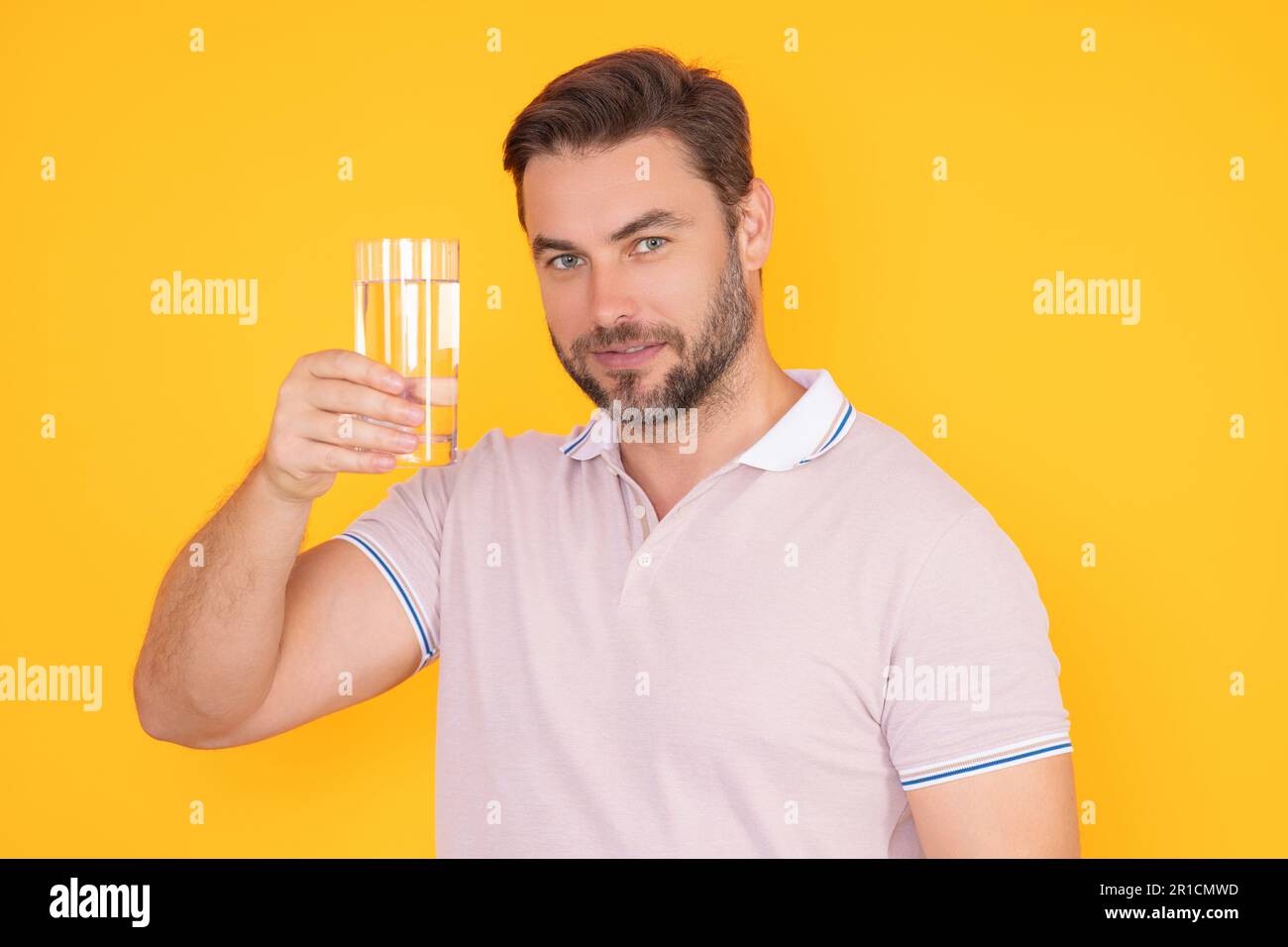 Man drinking a fresh glass of water isolated on studio background ...