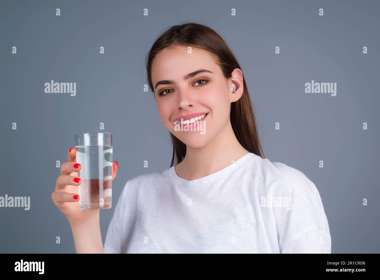 Girl drinking water, isolated on studio background. Young woman enjoy ...