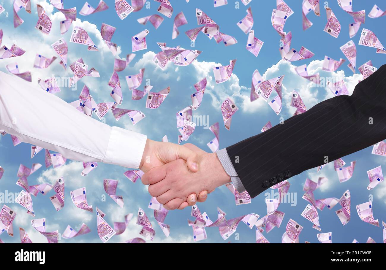handshake on a flying many 500 euro bills background Stock Photo - Alamy