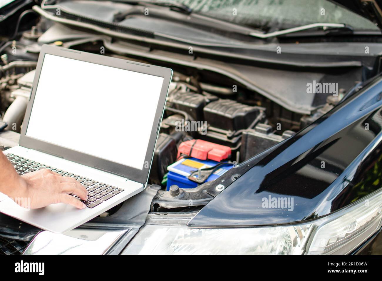 Closeup, A man's hand typing on a laptop computer keyboard to check the operation of the car ...