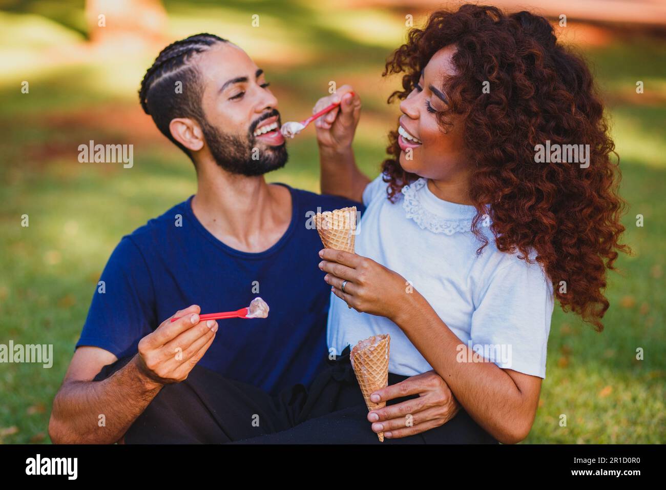 valentine couple eating ice cream in the park Stock Photo - Alamy