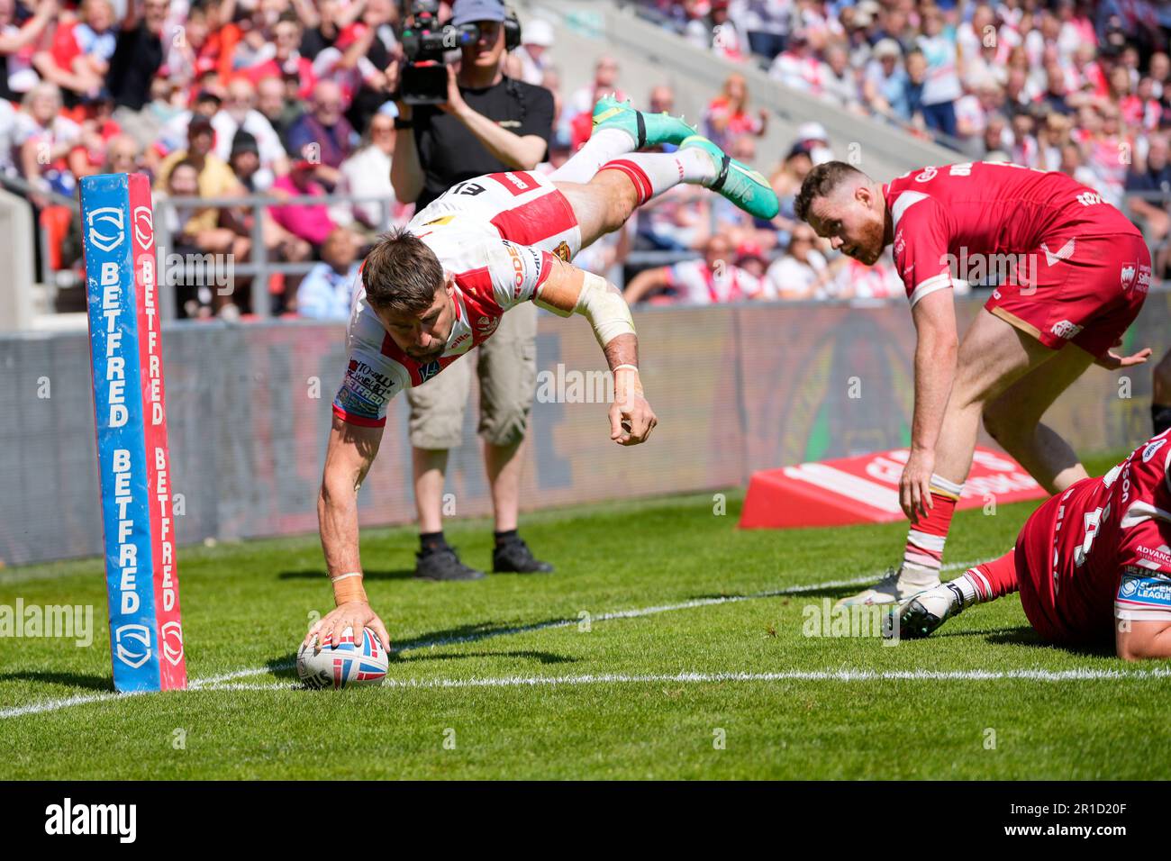 Tommy Makinson #2 of St. Helens dives over the line to score a try ...