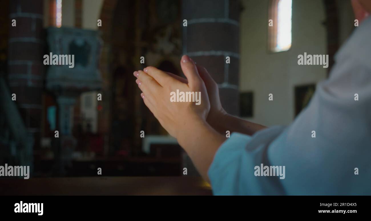 Christian woman folded hands in prayer inside a church. Religious faith ...
