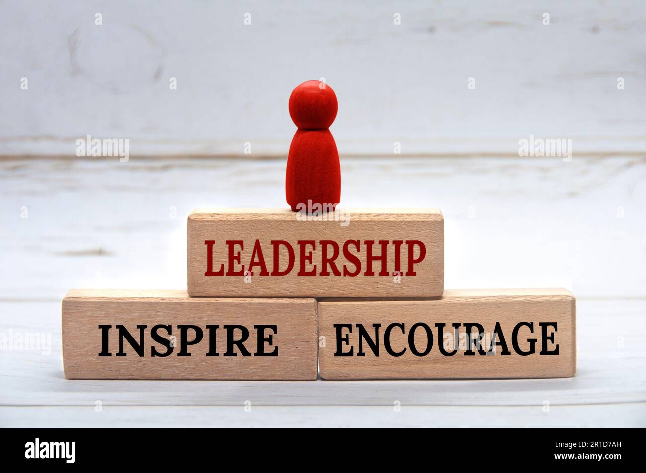 Leadership, Inspire and Encourage text on wooden blocks with red figure ...