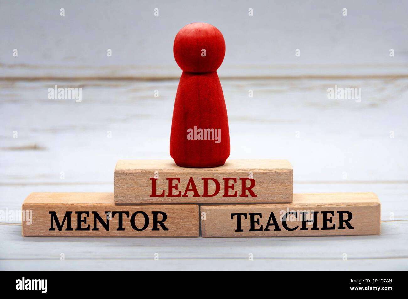 Leader, Mentor and Teacher text on wooden blocks with red figure on top ...