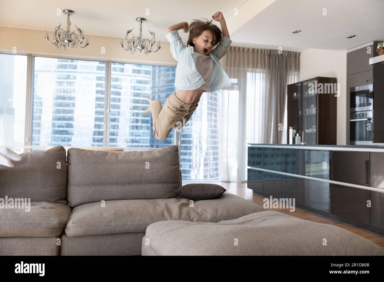Excited crazy boy kid jumping on big sofa Stock Photo - Alamy