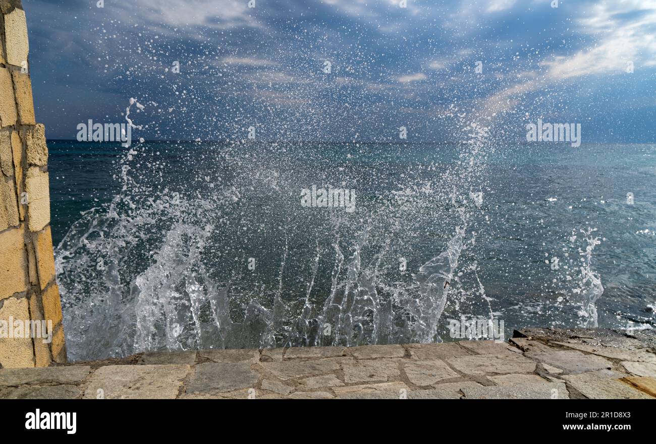 Sea waves beat on the rocks of the shore and scatter in different ...