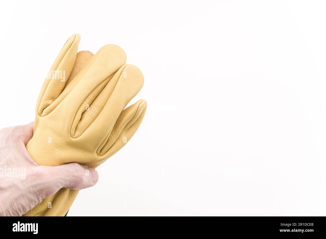 close up view of a person left hand holding a pair of yellow leather ...