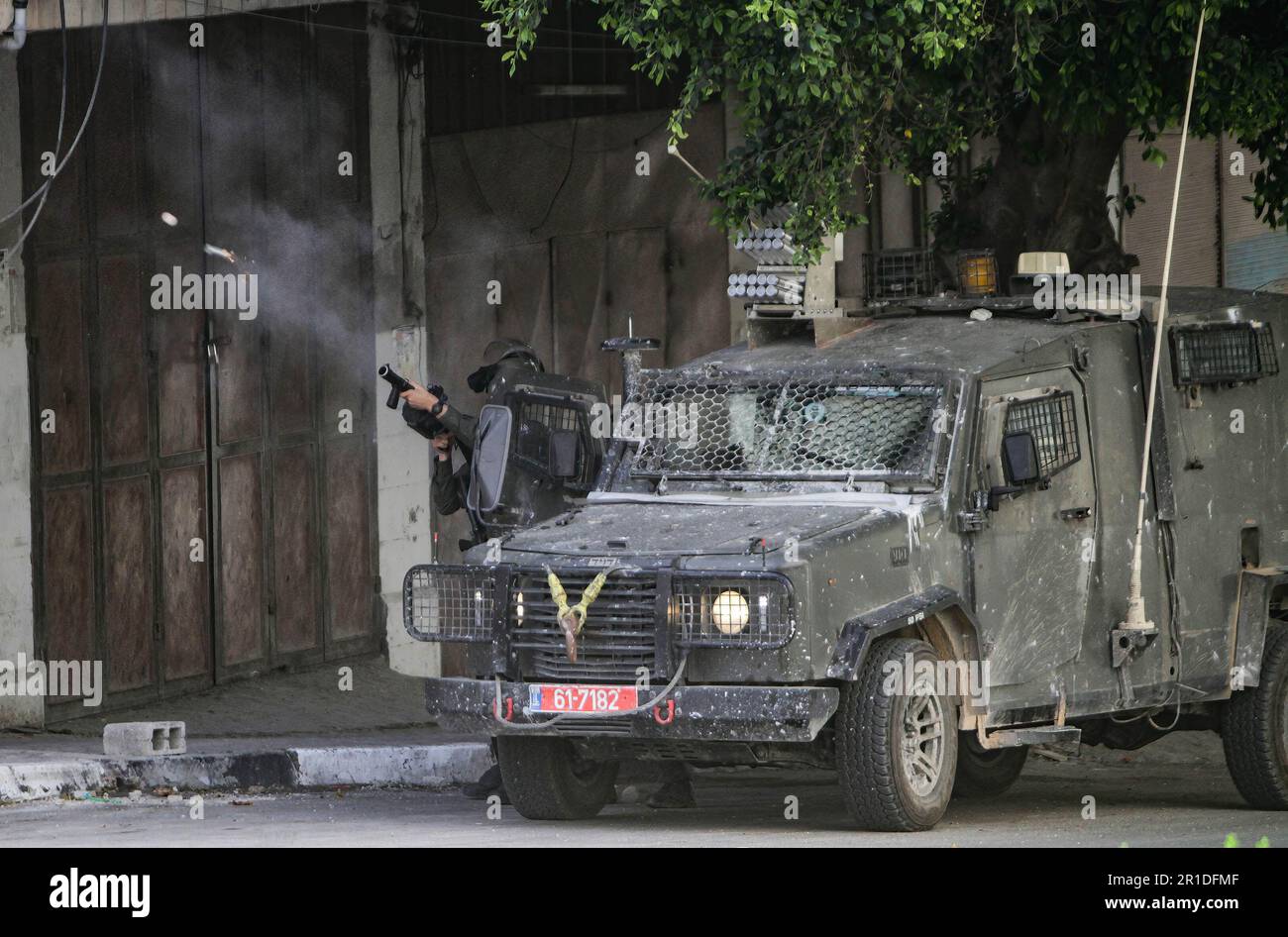 An Israeli soldier fires tear gas canisters during a raid at Balata ...