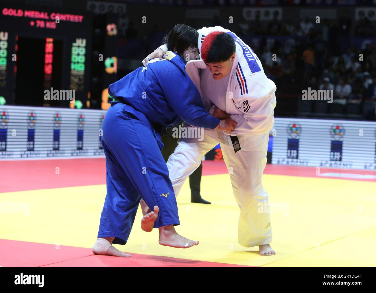 Akira Sone of Japan, in blue, and Julia Tolofua of France compete during their women's +78kg ...
