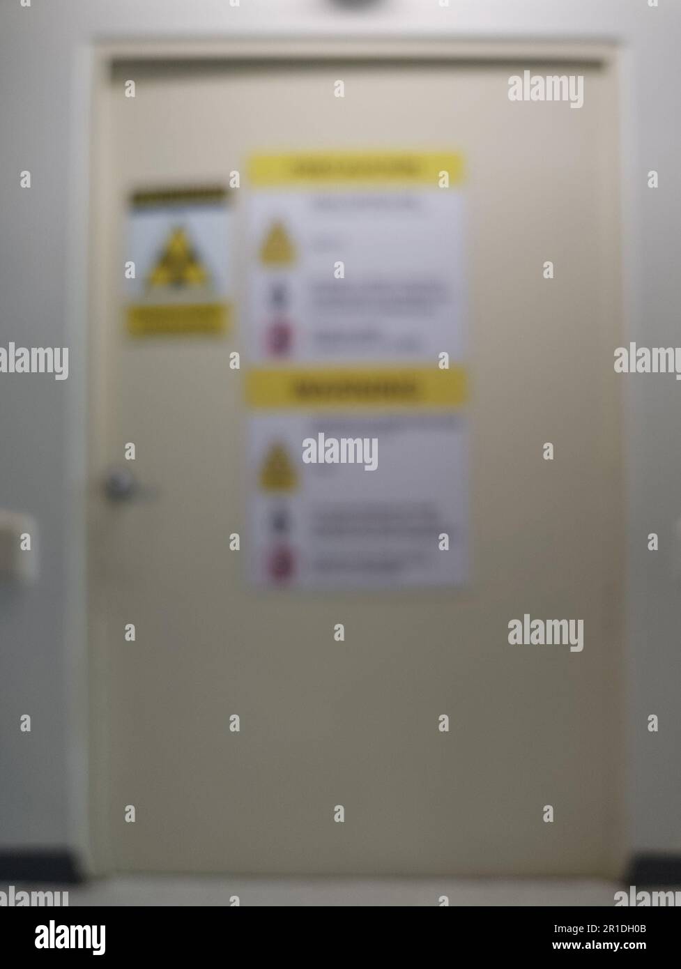 Xray room door with warning signs blurred background Stock Photo - Alamy