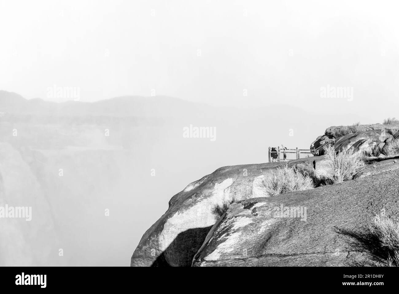 Tourists are drenched by the spray of falling water at a viewpoint at ...