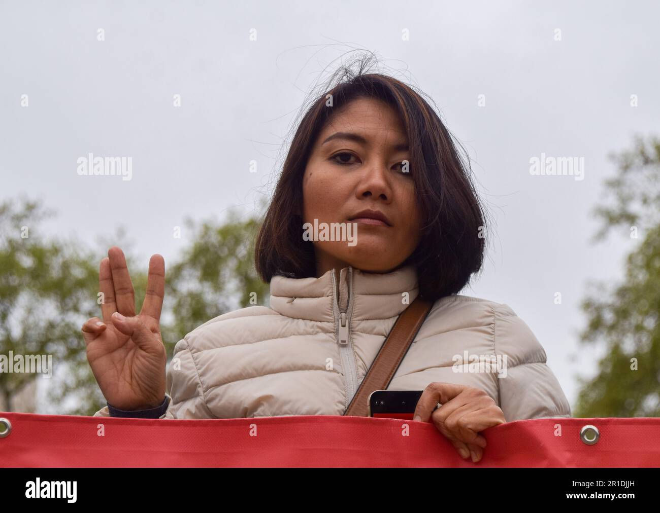 London, England, UK. 13th May, 2023. A protester holds up the three ...