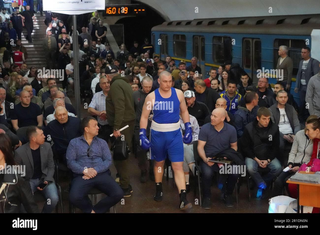 Spectators watch as a boxer approaches the ring to start a national ...