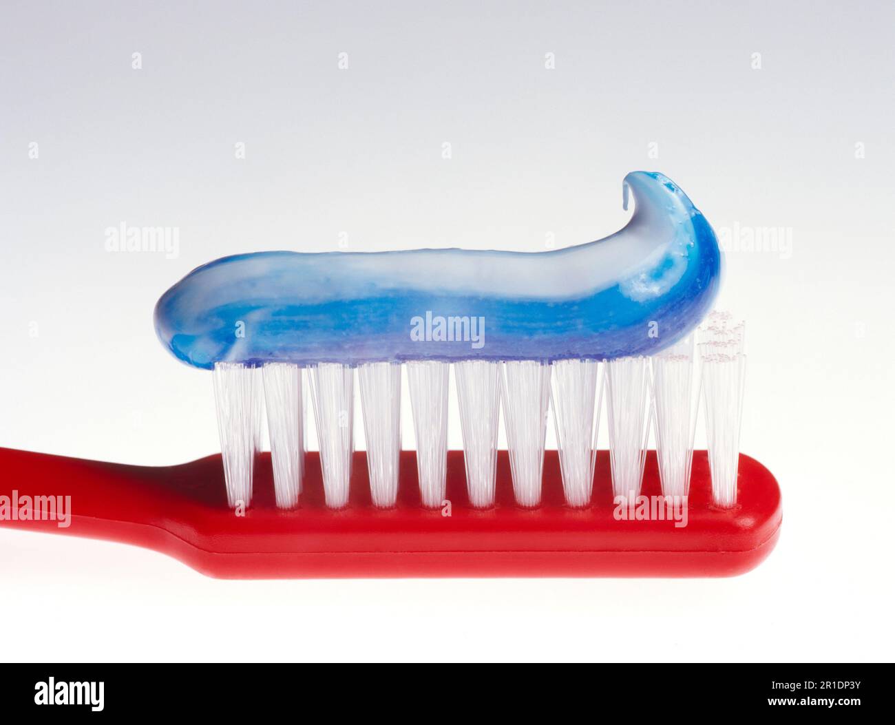 Toothbrush with blue toothpaste close-up on white background Stock ...
