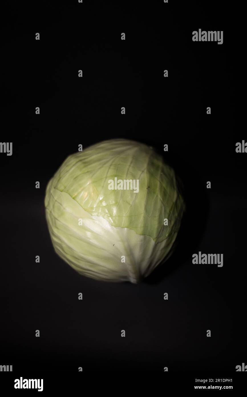 Vertical photo. Head of white cabbage on black background. Fresh green ...