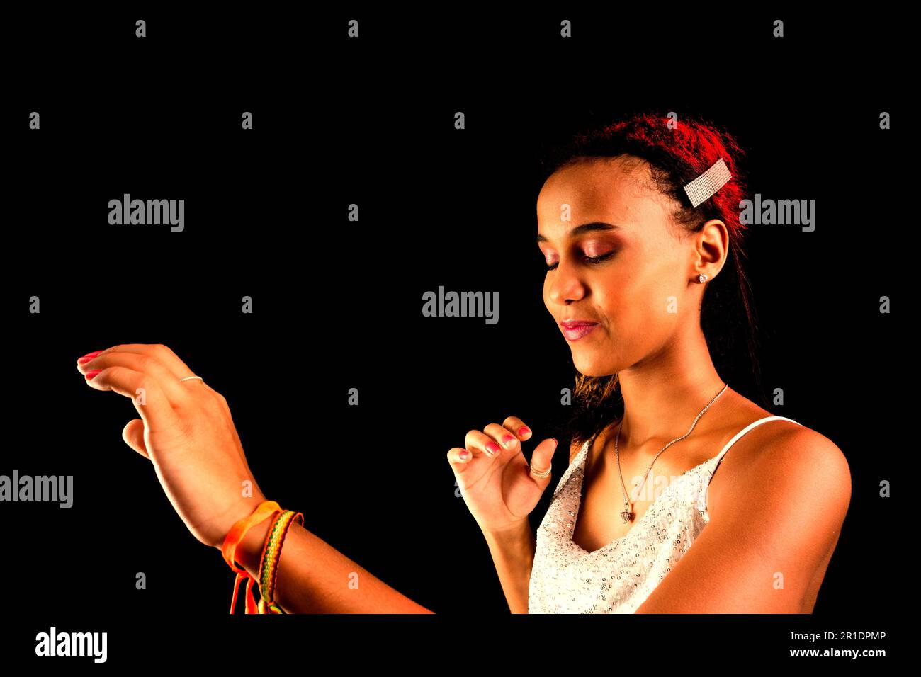 Studio portrait of pretty teenage girl making hand gestures at camera ...
