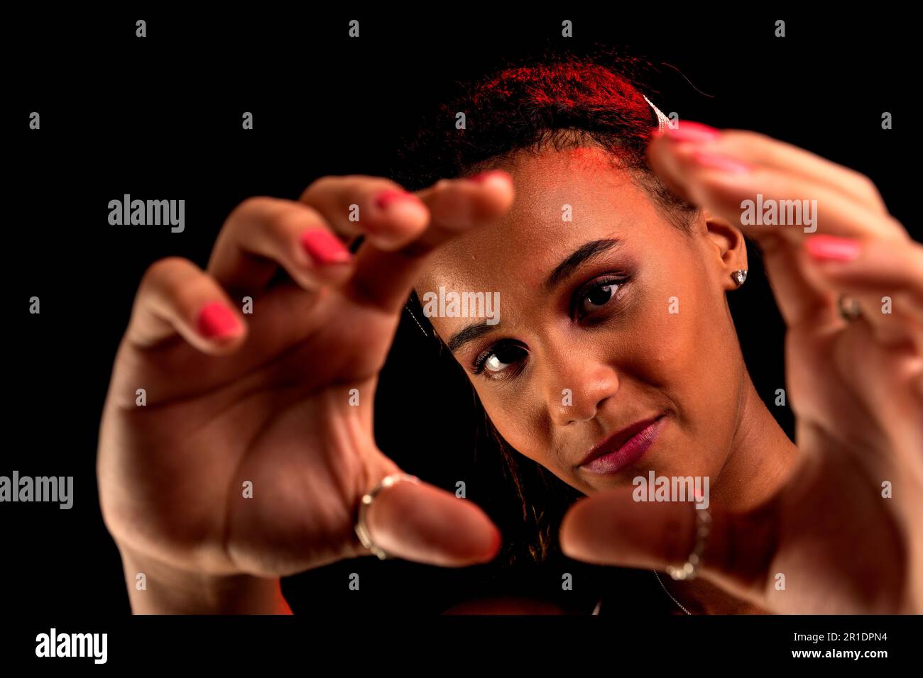 Studio portrait of pretty teenage girl making hand gestures at camera ...