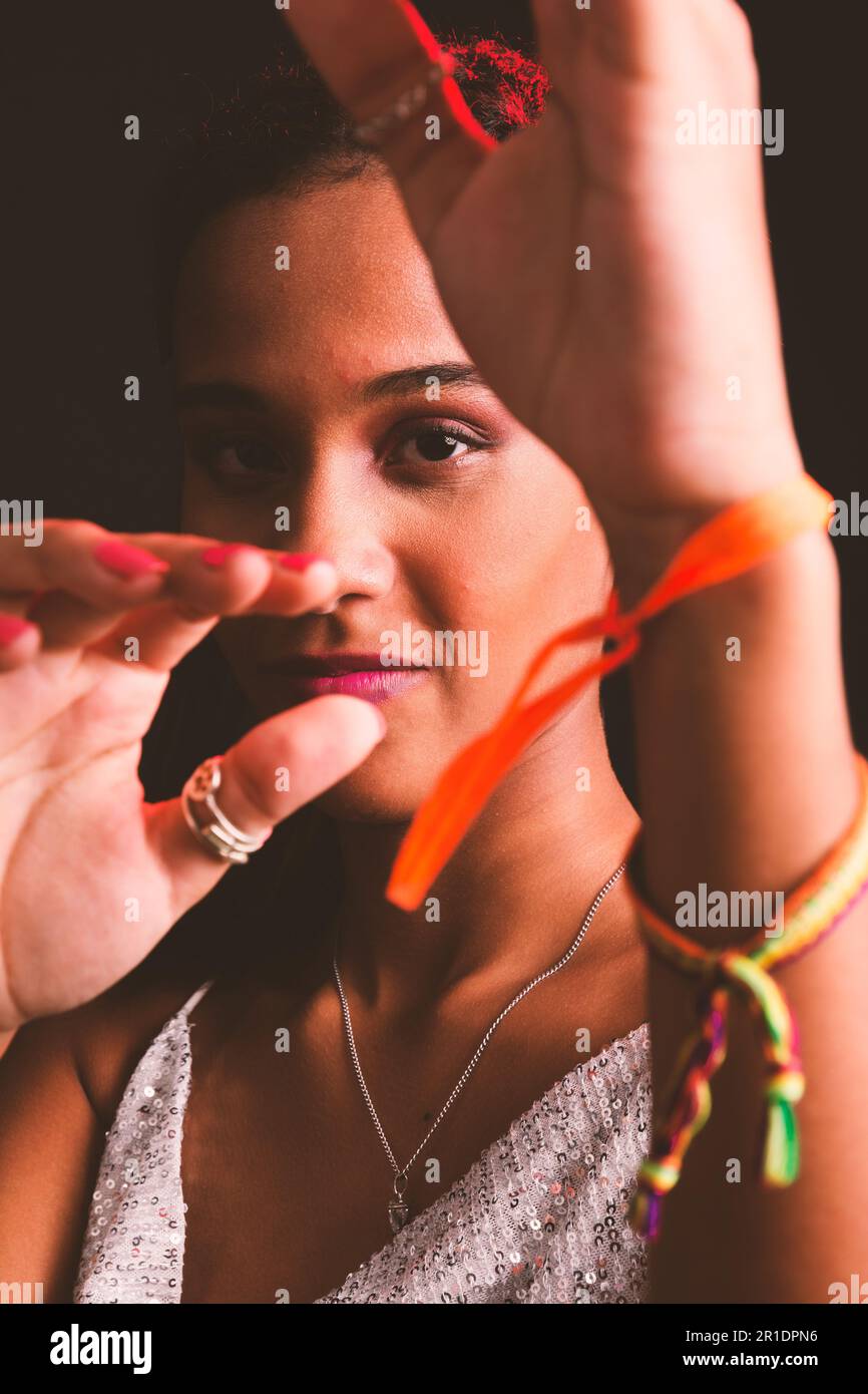 Studio portrait of pretty teenage girl making hand gestures at camera ...