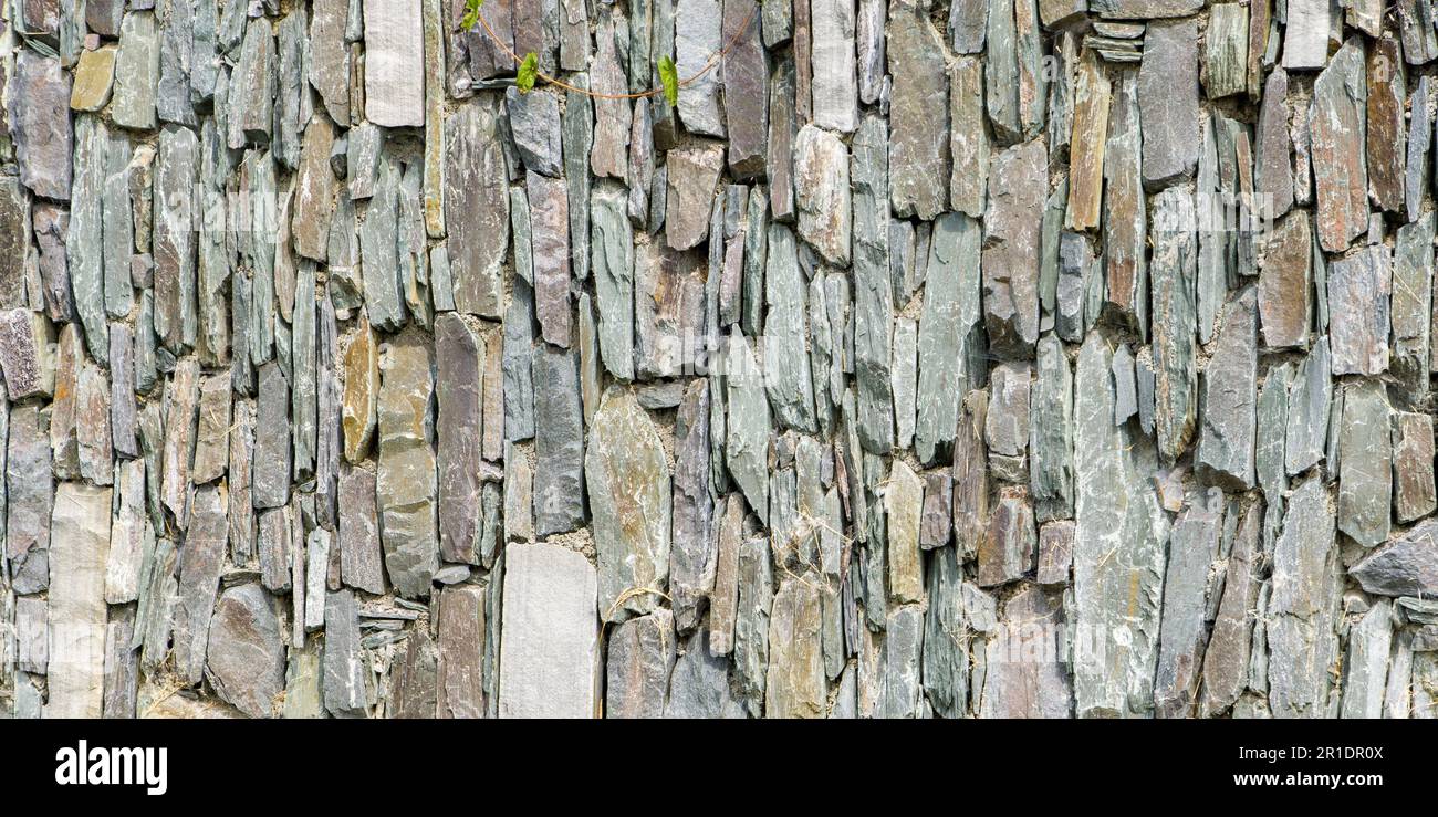 A fence made of stone plates as a background. Stone background. The ...
