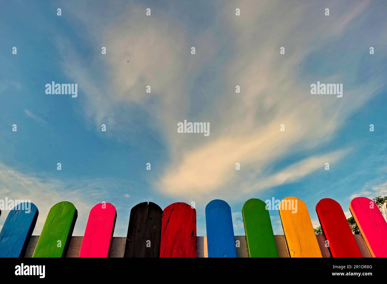 colorful fence against the background of a bright blue sky in a park ...