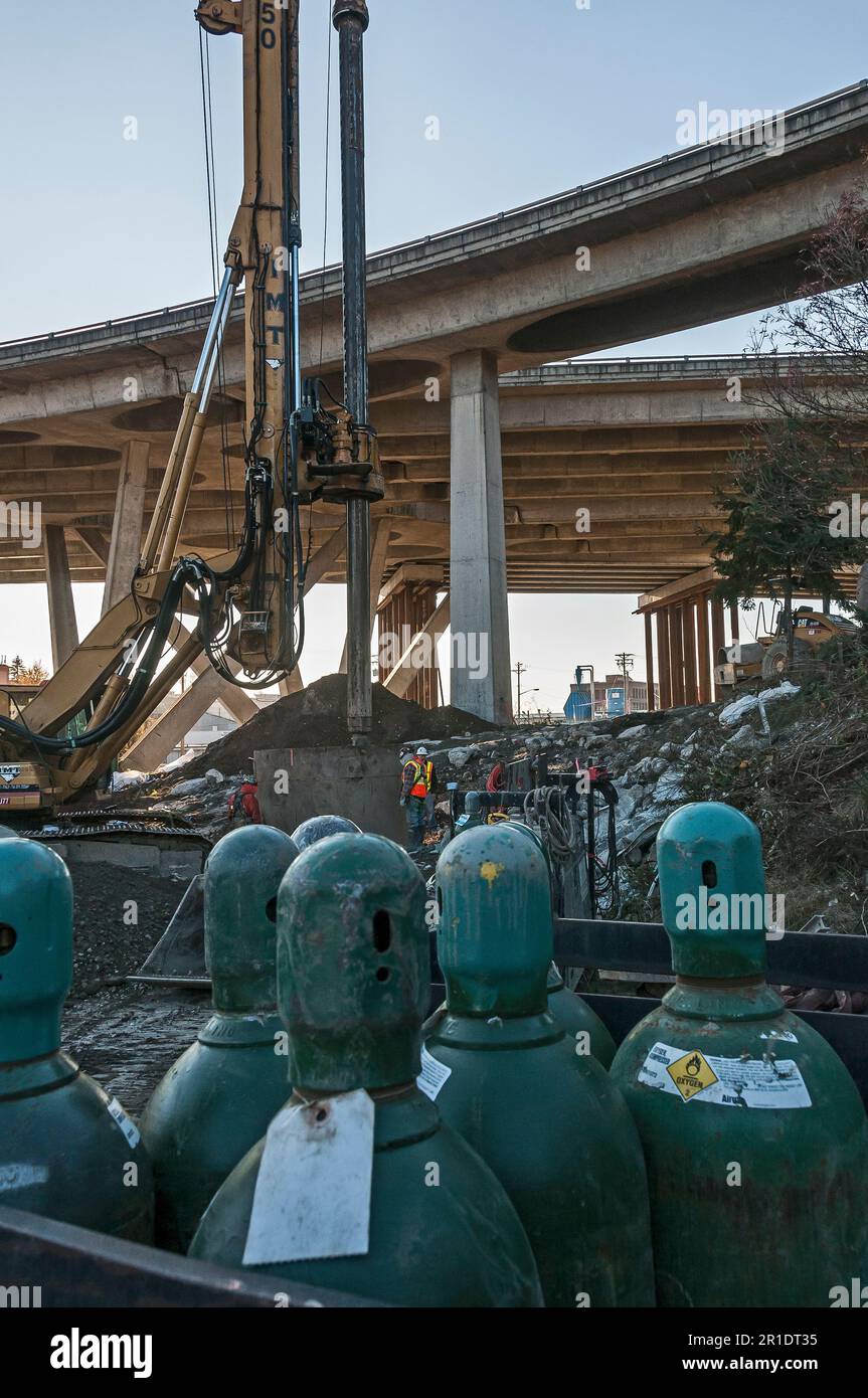 Oxygen tanks are in the foreground with a drilling rig for digging ...